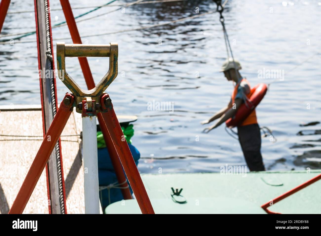 Male lifeless mannequin in life jacket and life buoy hanging by ropes ...