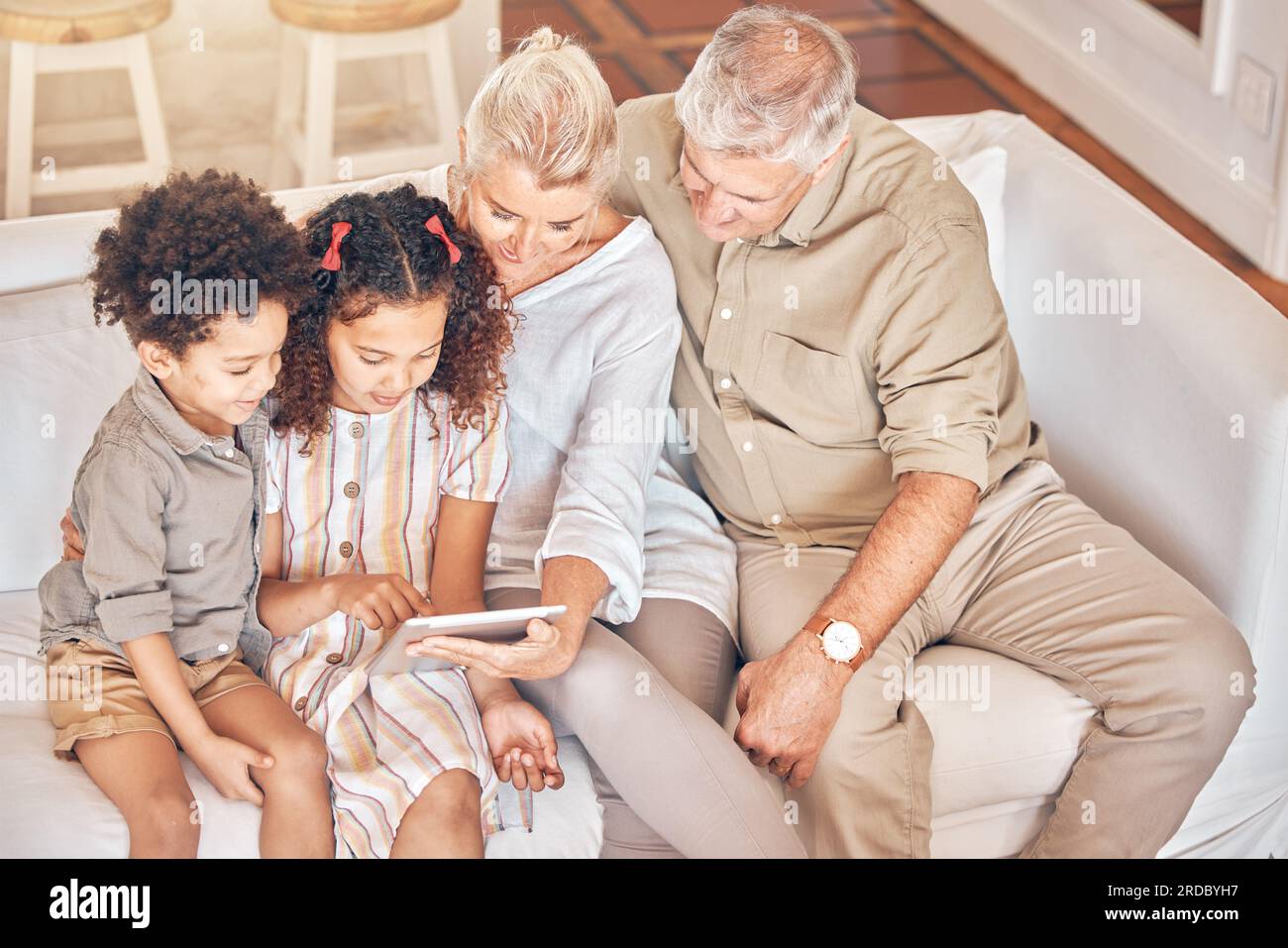 Grandparents, tablet and children in home, learning and bonding ...
