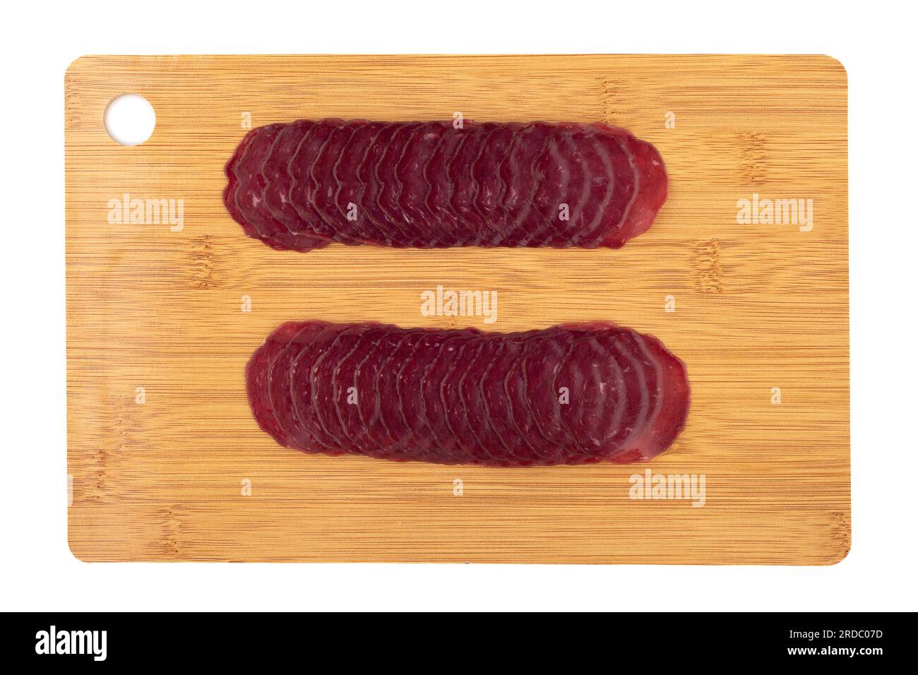 Slicing pastrami on a cutting board on a white background. Copy space ...