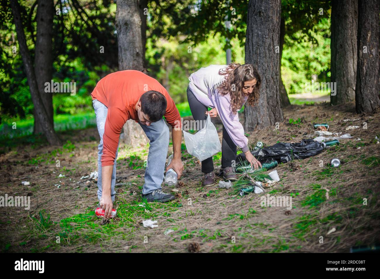 Young couple collect garbage thrown in nature park. Protection ...