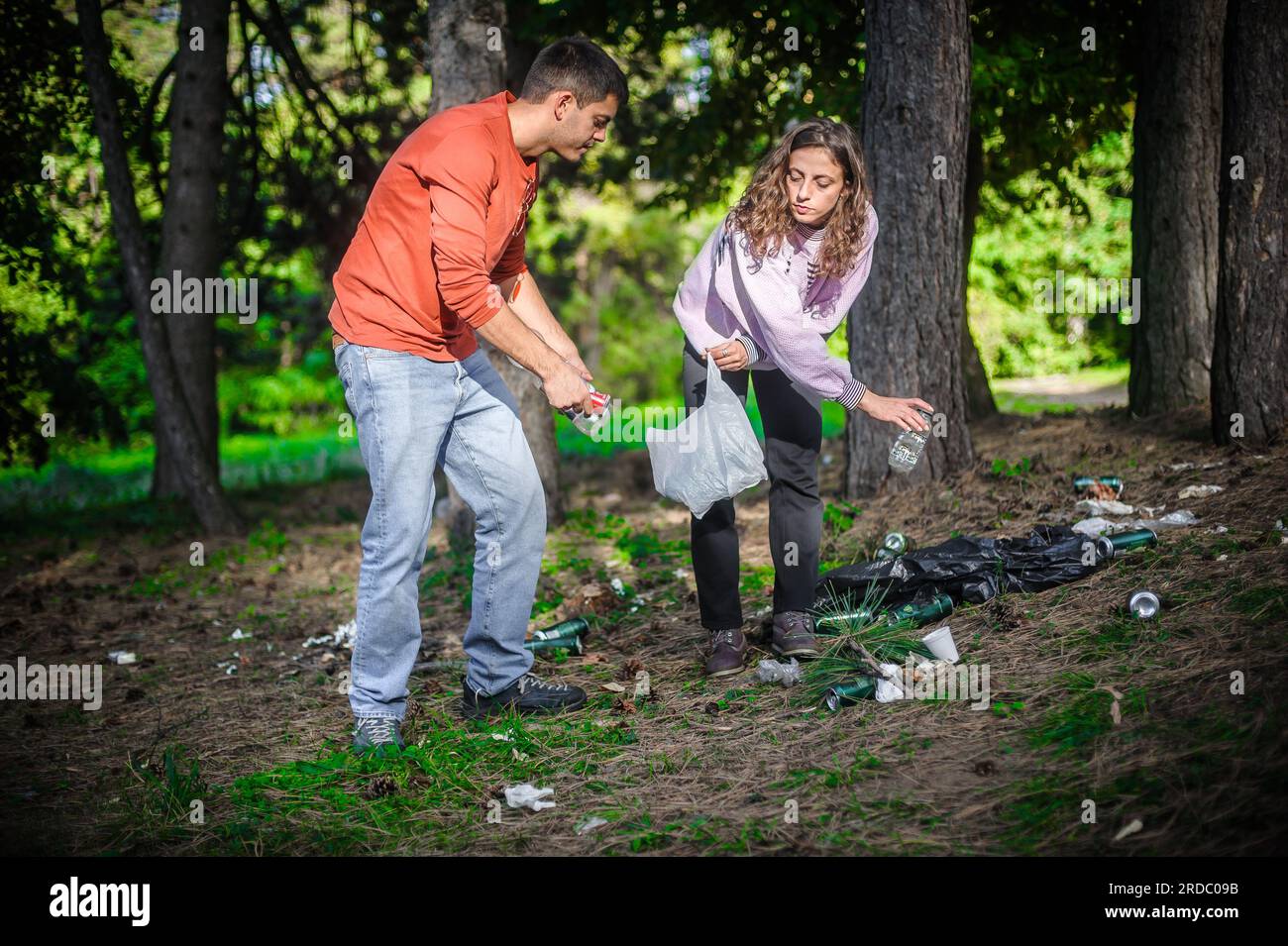 Young couple collect garbage thrown in nature park. Protection ...