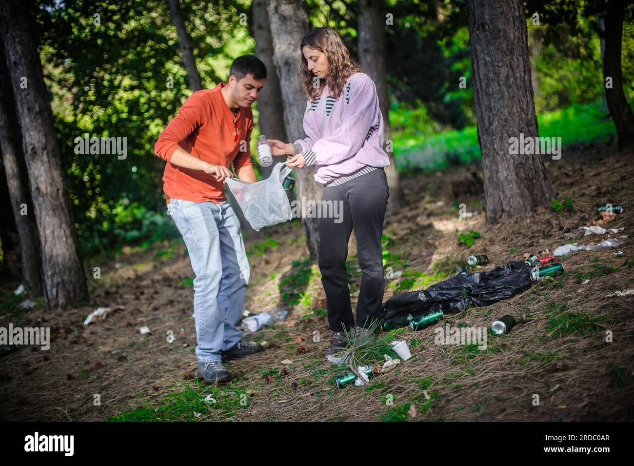 Young couple collect garbage thrown in nature park. Protection ...