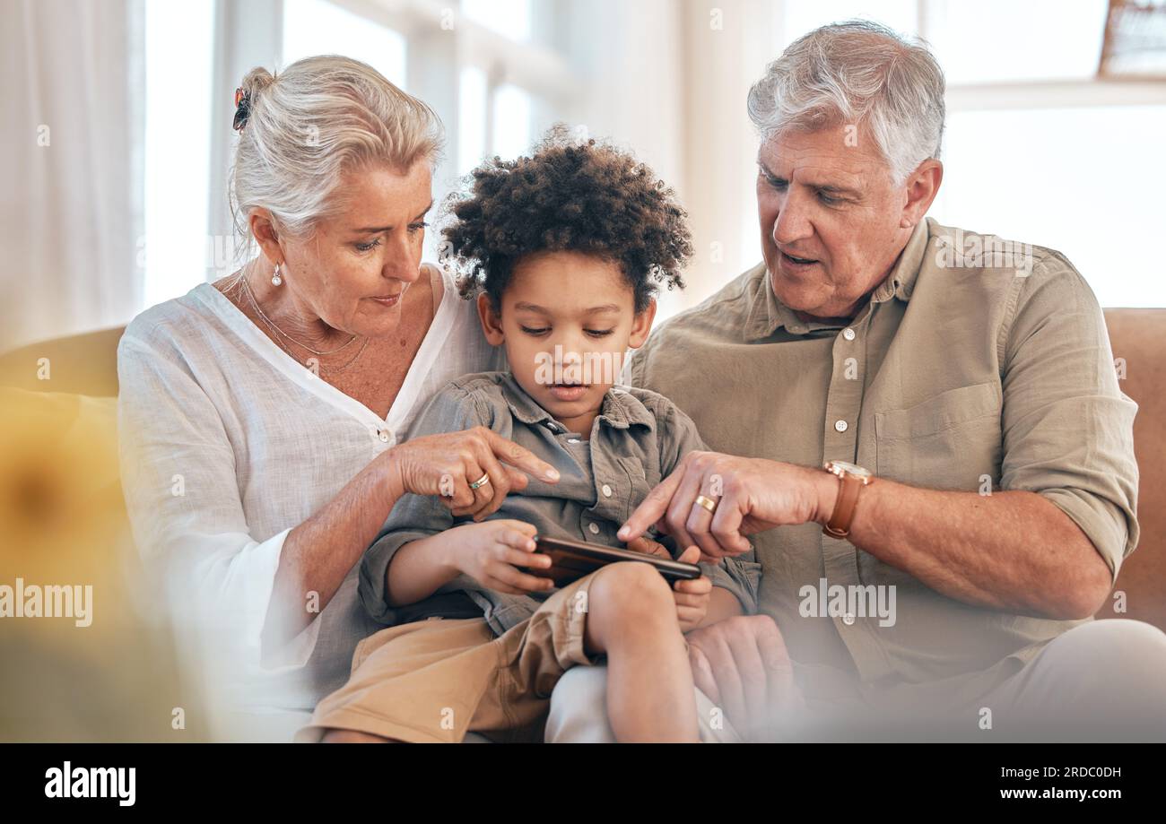 Grandparents, phone and child in home pointing, learning and bonding ...
