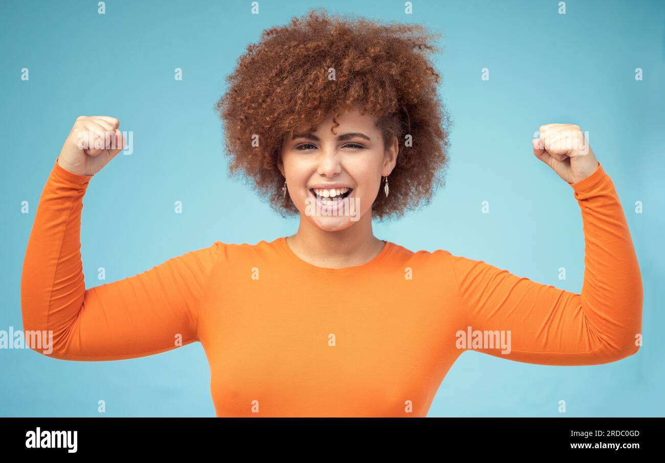 Portrait, strong and bicep with a black woman in studio on a blue ...
