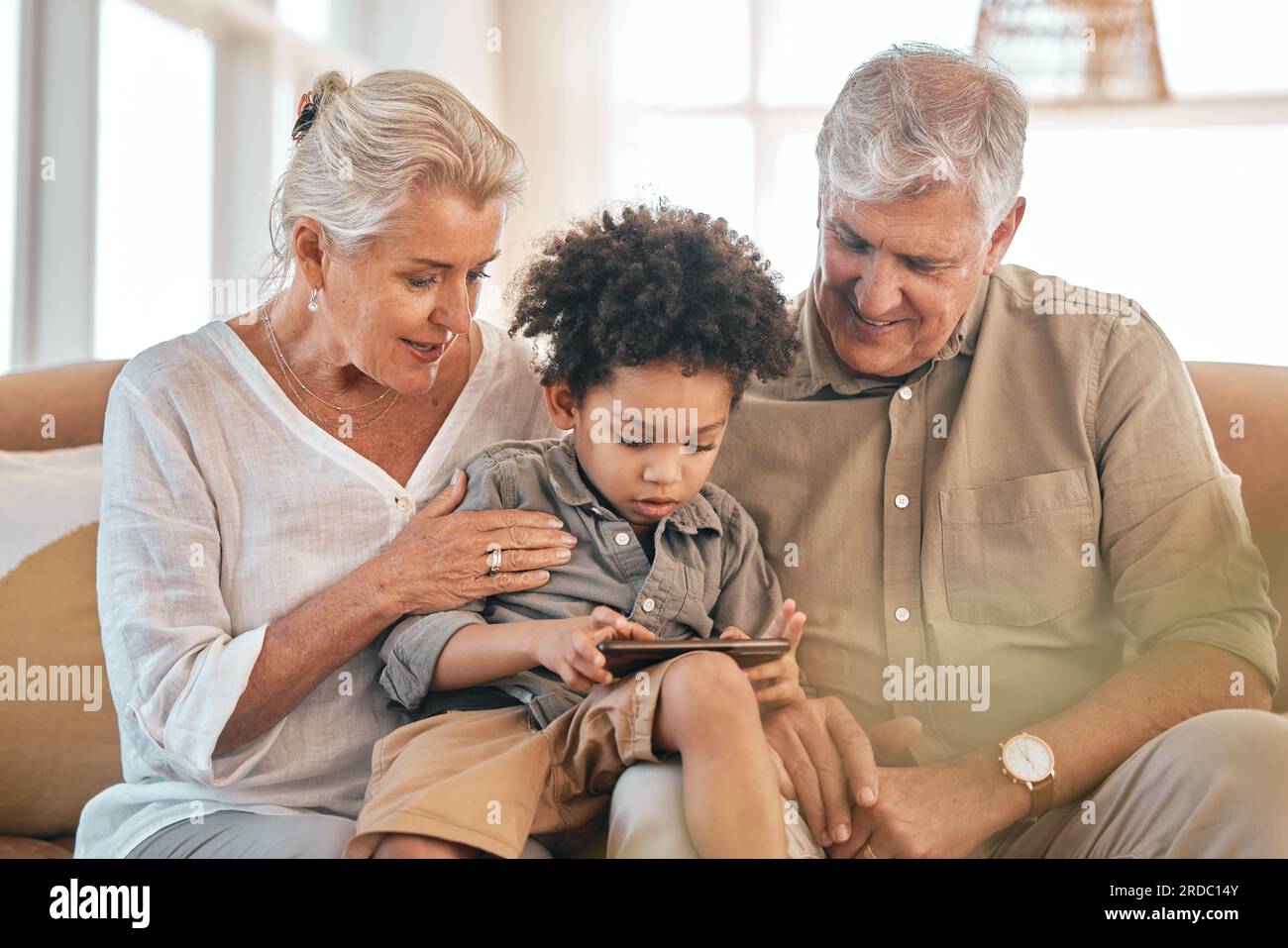 Phone, grandparents and child in home, happy and bonding together in ...