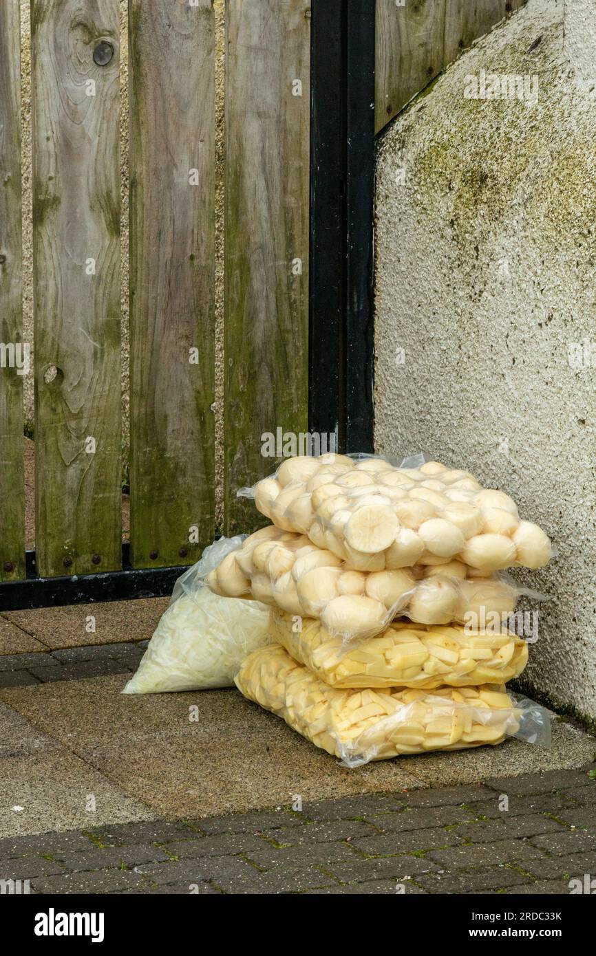 Catering sized bags of pre-prepared potatoes and chips waiting outside ...