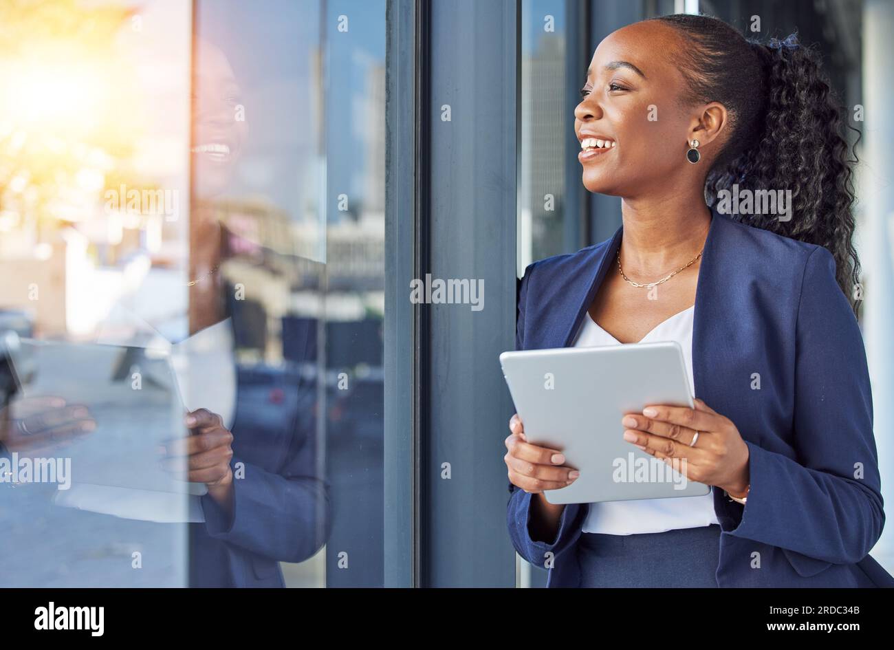 Happy woman, thinking and tablet at window in office, smile and ideas ...