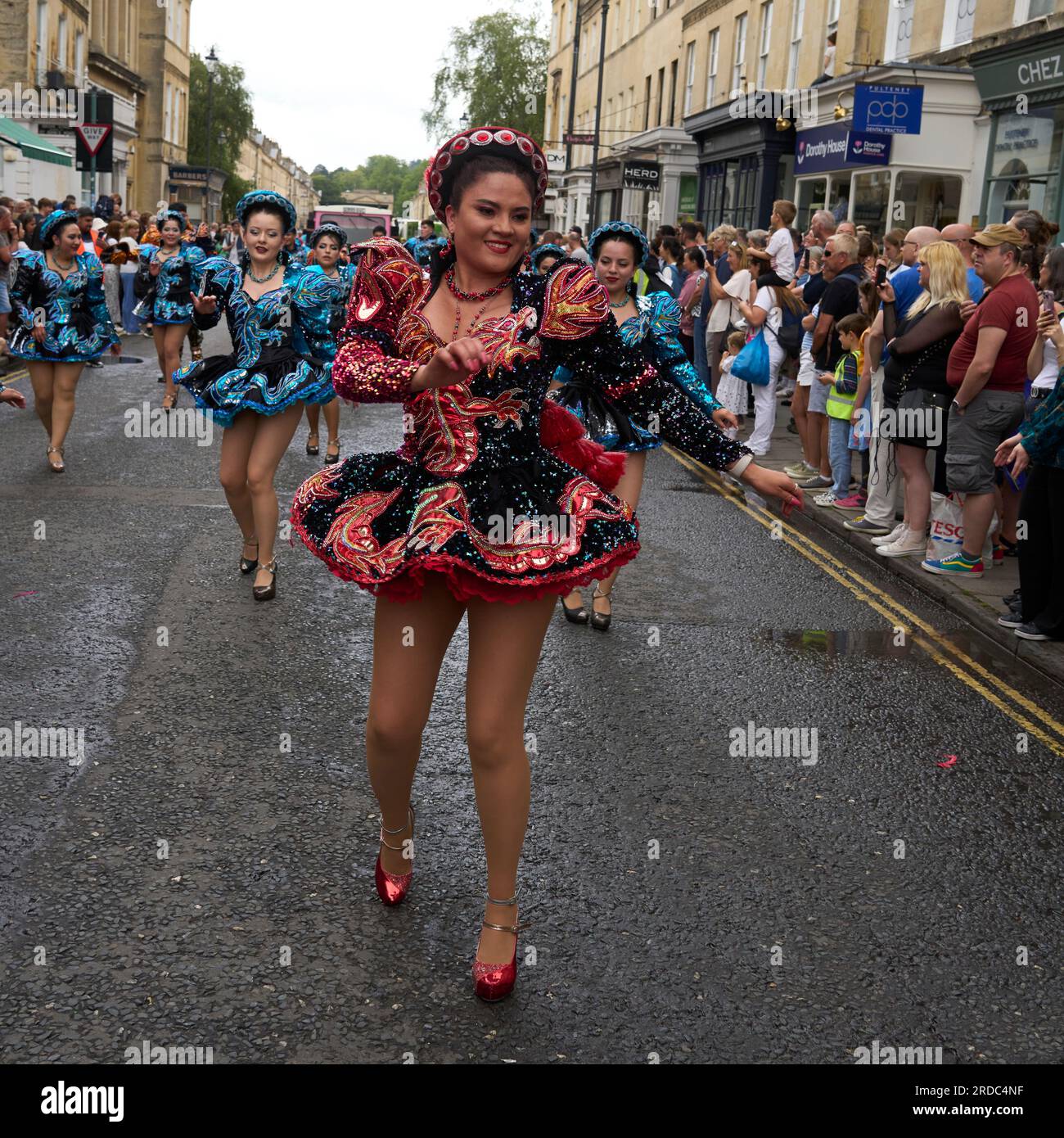 Dancers and musicians dressed in ornate costumes parade through the ...