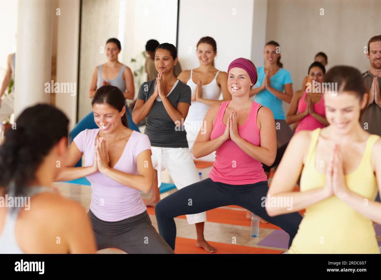 Enjoying their yoga workout. Shot of a group of smiling yoga students ...