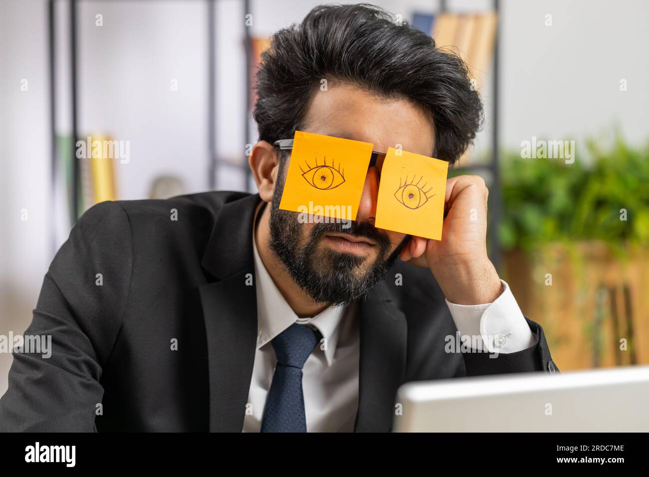Inefficient tired young businessman working sleeping on laptop computer ...