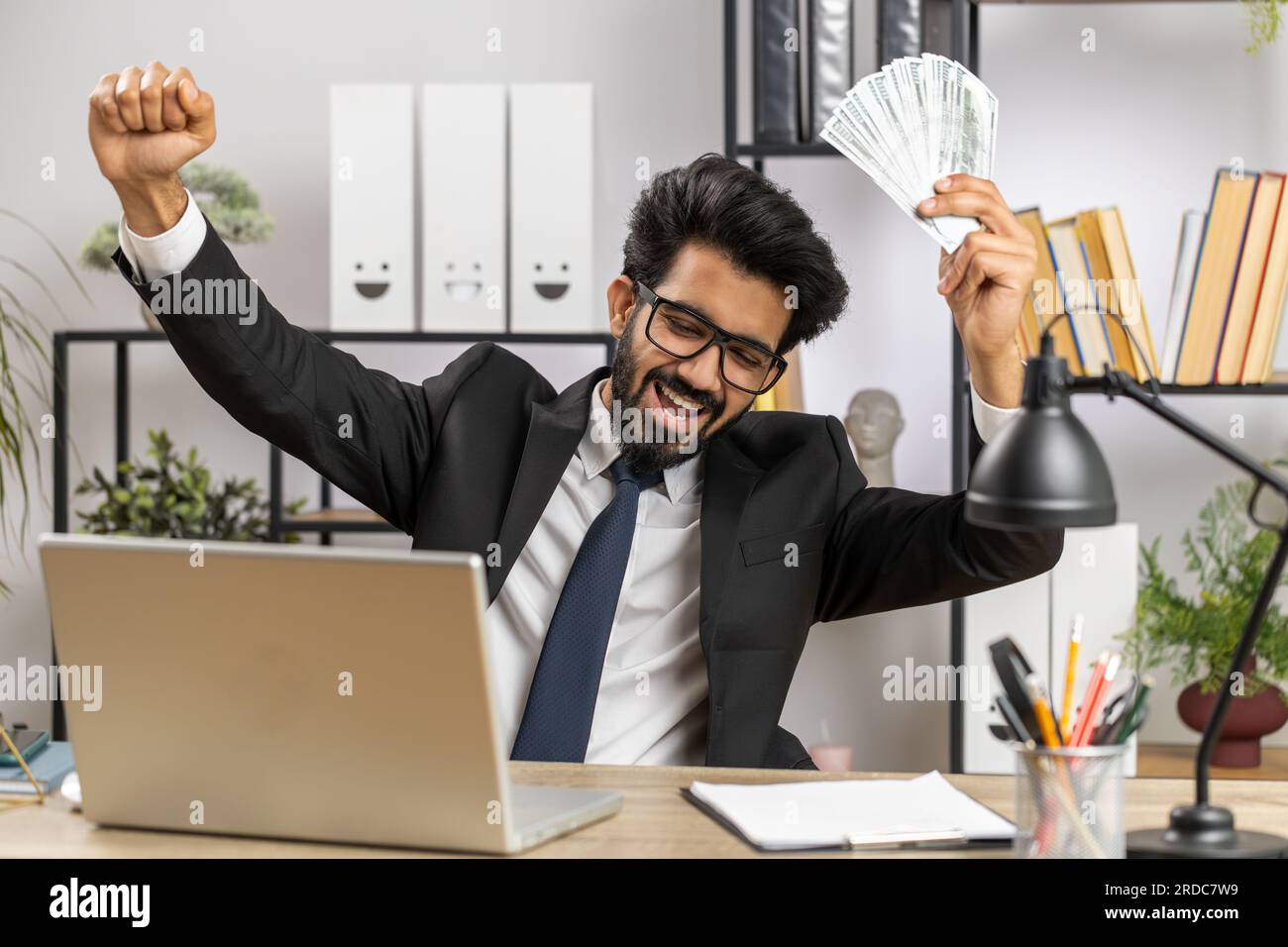 Indian businessman holding fan of cash money dollar banknotes celebrate ...