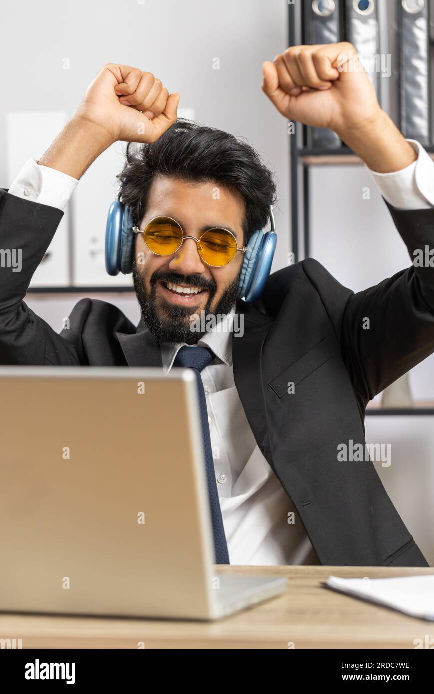 Happy relaxed overjoyed indian businessman working on laptop computer ...