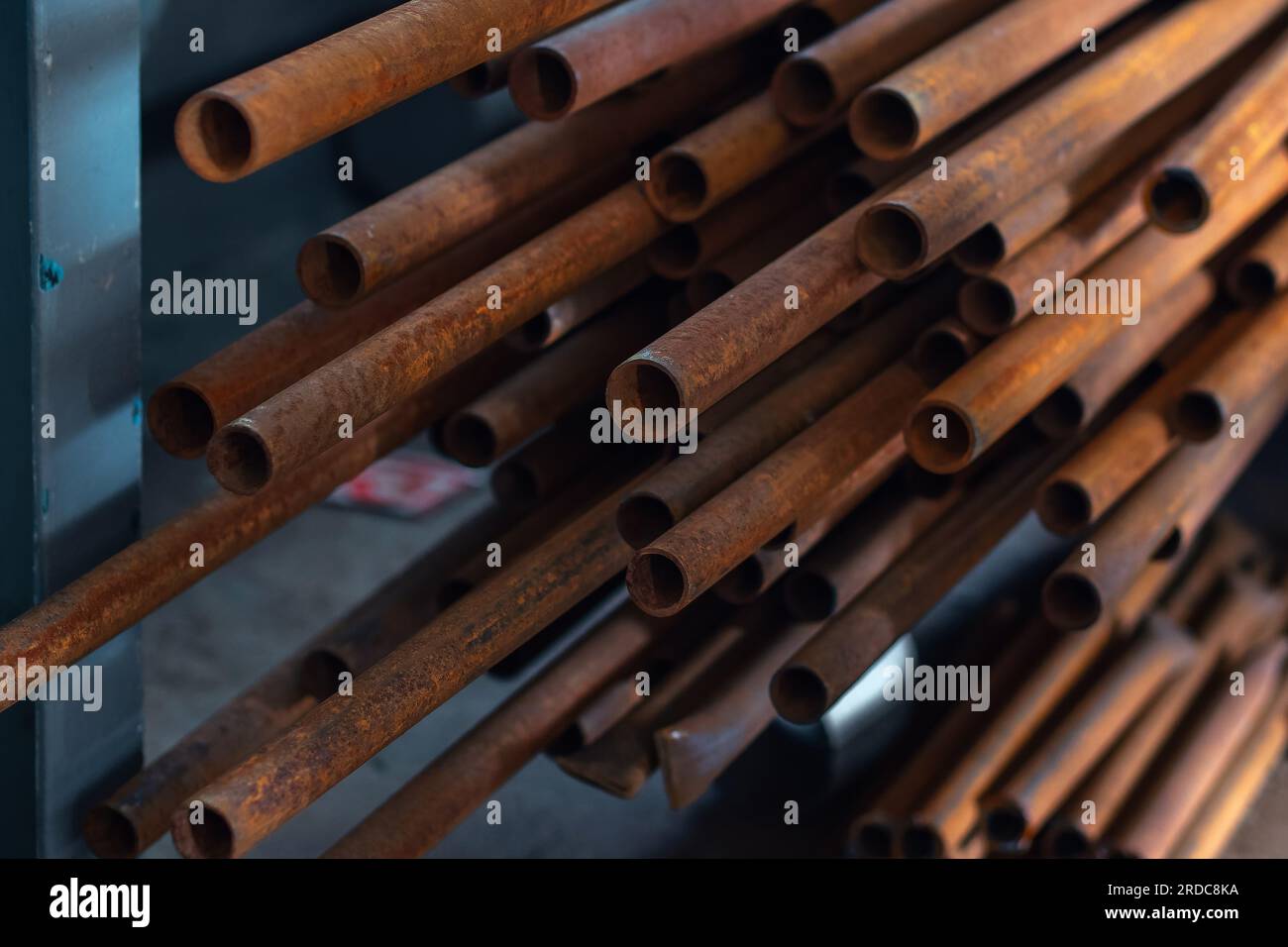 Round metal pipes of small diameter lie in stack. Front view. Pipes for ...