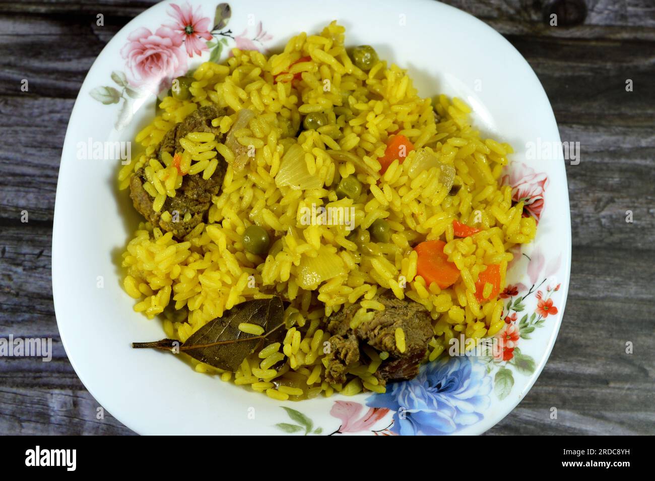 A plate of hot steamed long grain yellow Basmati rice with vegetables ...