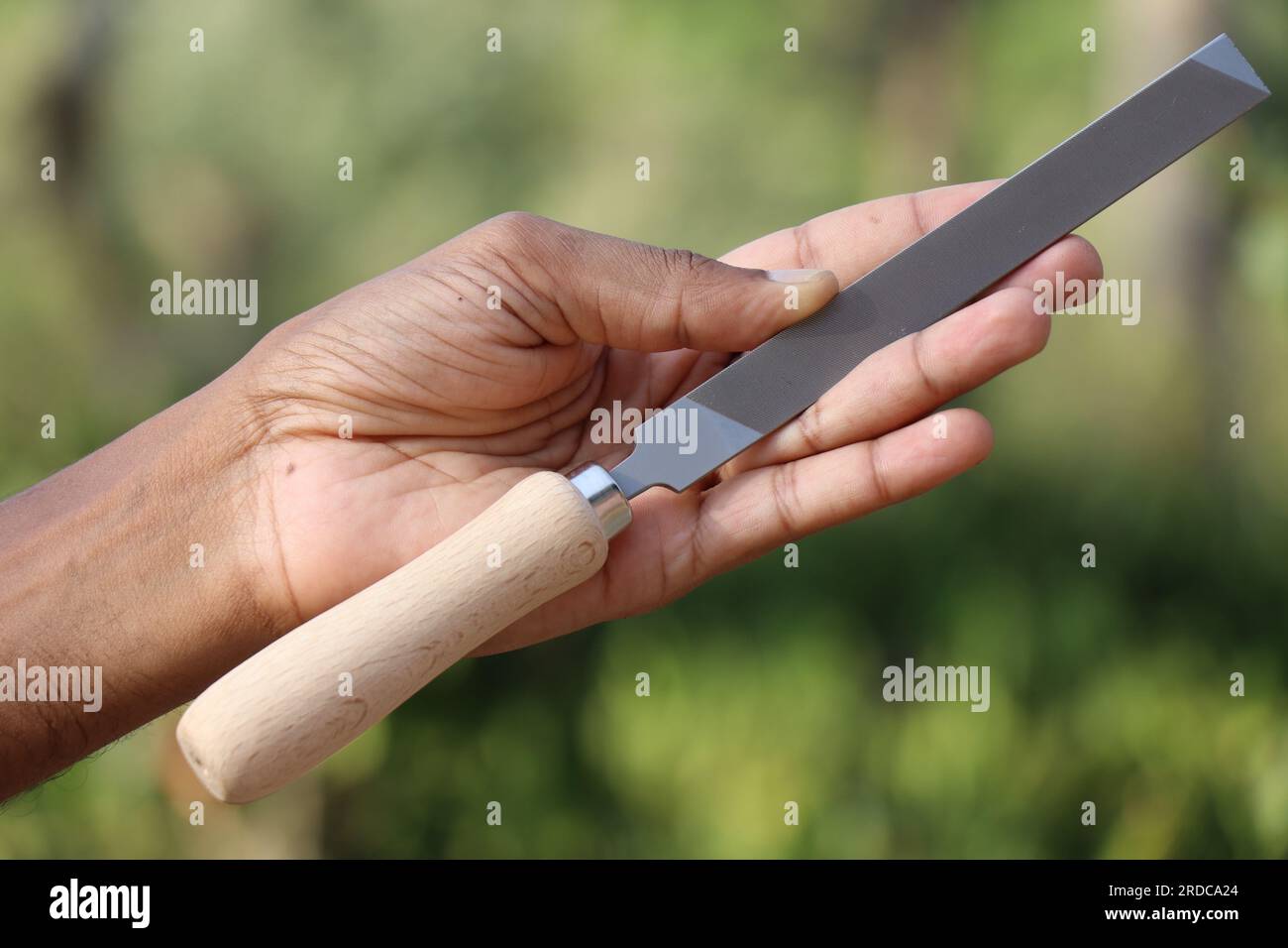 New Iron file tool with wooden handle held in the hand isolated on ...