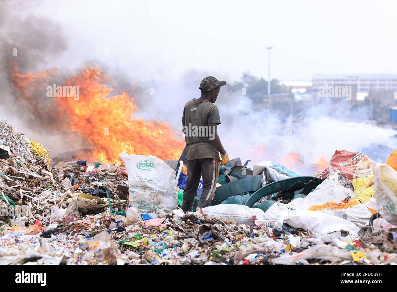 A man seen burning garbage at Dandora dumpsite. Nairobi City County ...