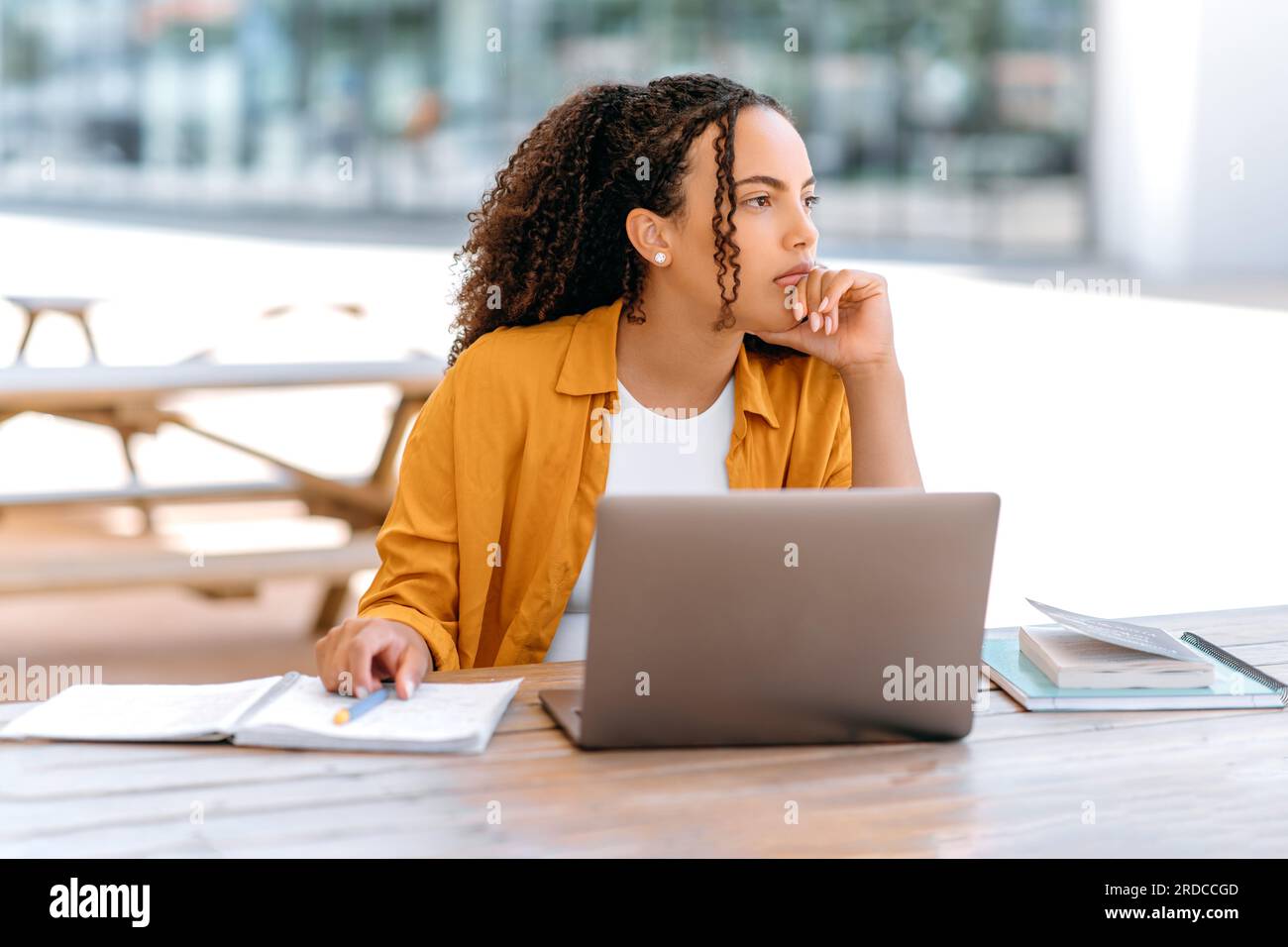 Pensive bored mixed race curly haired young woman, freelancer, female ...