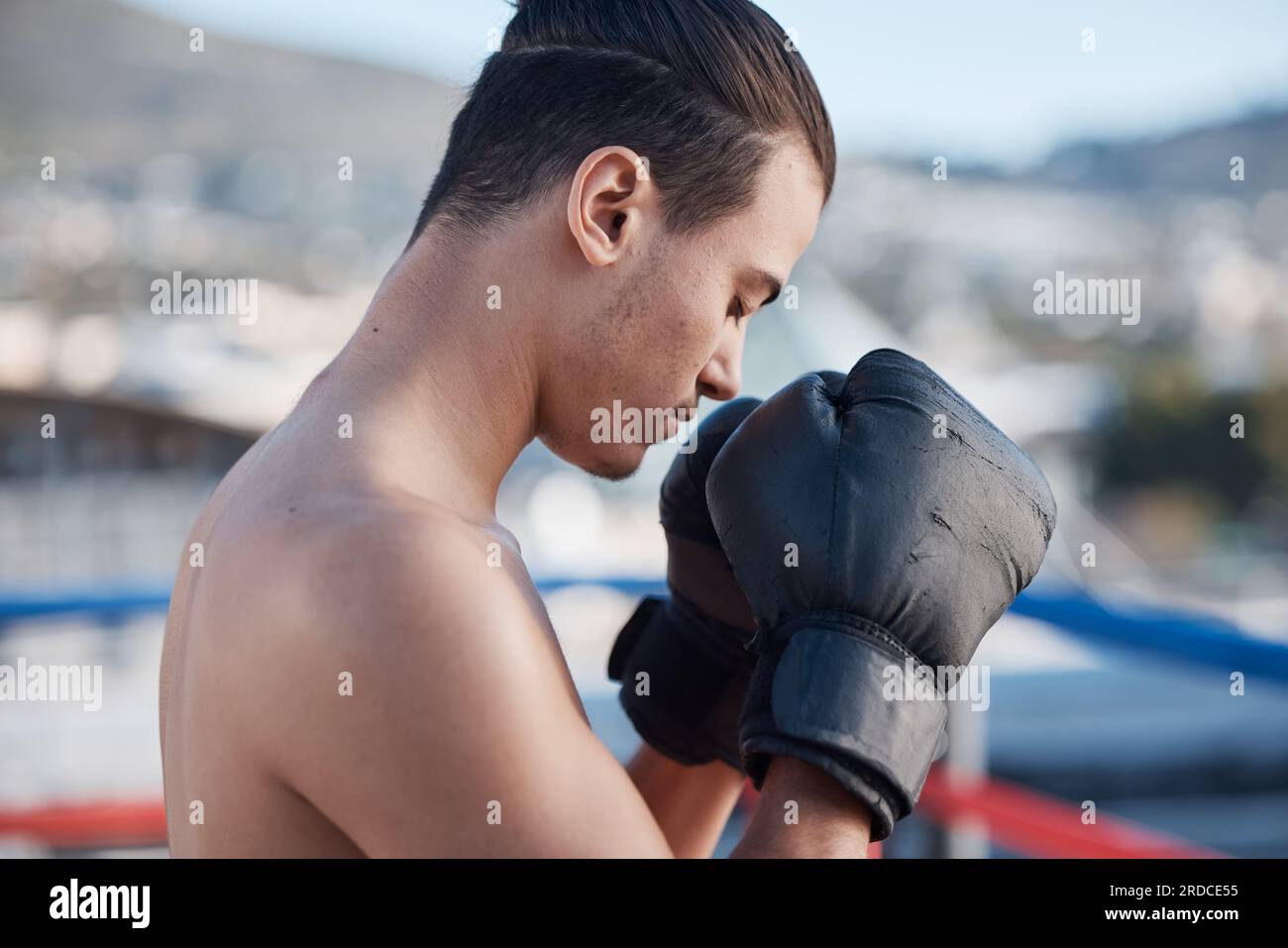 Sports, boxer praying or man fighting in a ring on rooftop in city for ...