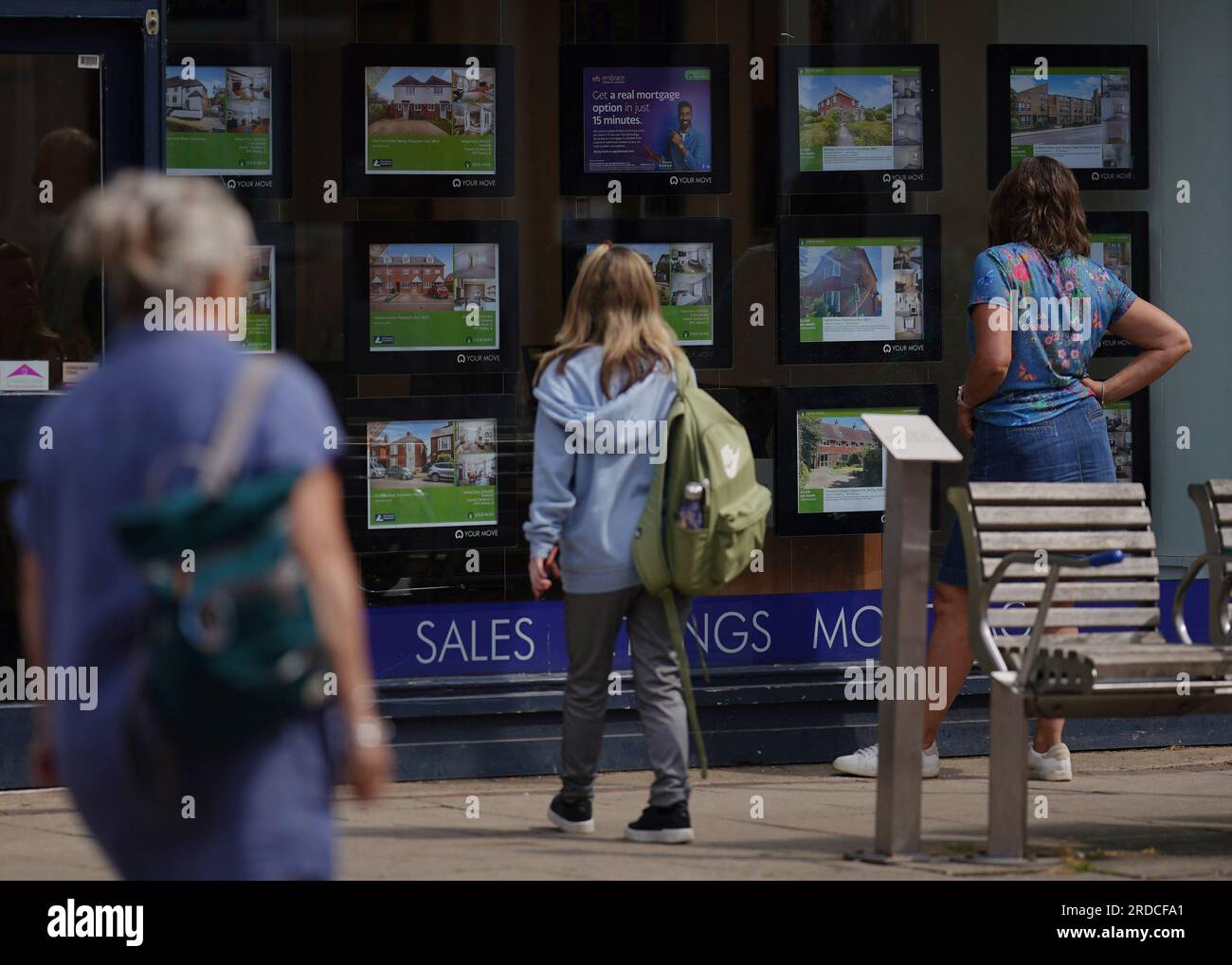 People looking at advertisements in an estate agents window in ...