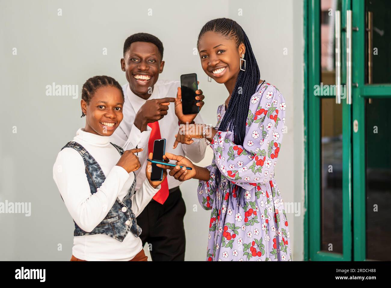 Photo of a diverse group of people smiling and pointing at cellphone ...