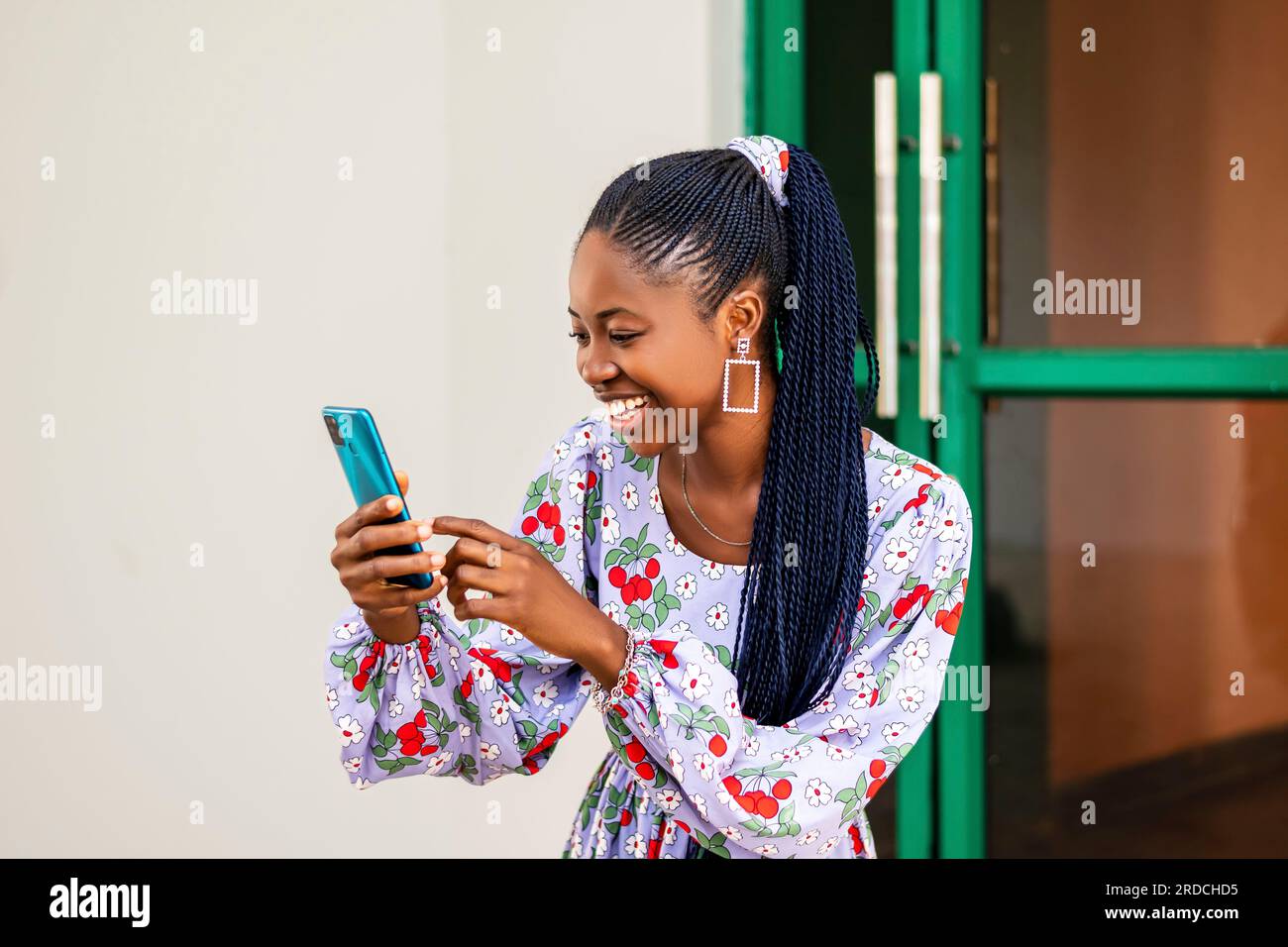 young joyful African woman smiling while using her cell phone Stock Photo - Alamy