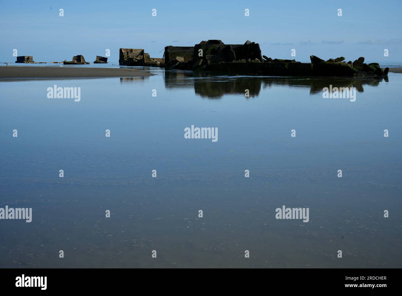 Remains of the WW2 D-Day Mulberry Harbour at Asnelles Beach reflected ...