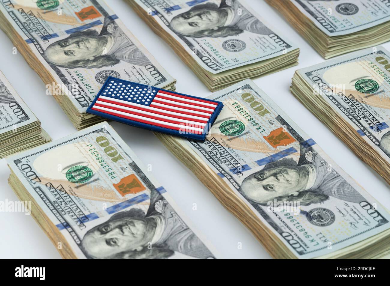 American flag on 100 US dollar bill piles lay on white studio ...