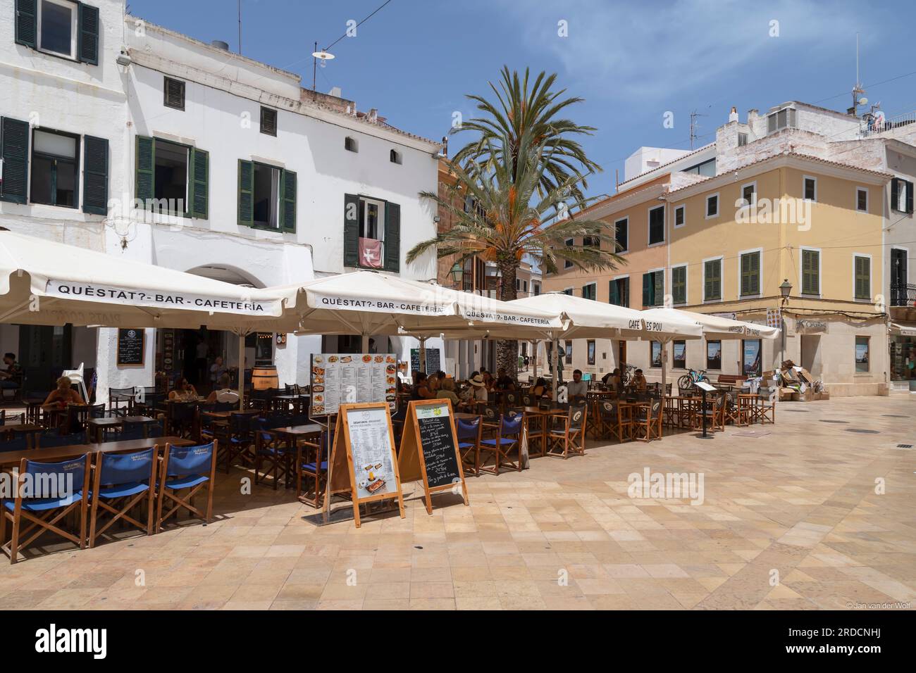 People drink and eat on the terraces of the restaurants in a cozy ...