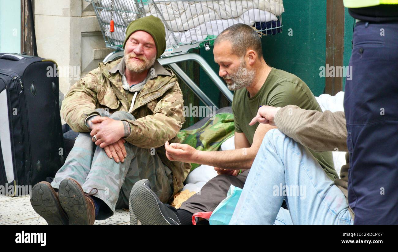 Three homeless men argue in the doorway of an empty department store on ...