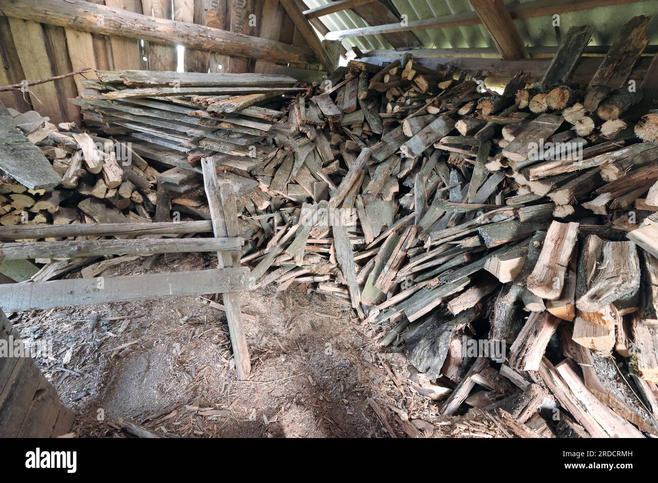 Chopped firewood in an old barn. Neatly folded. You can see a device ...