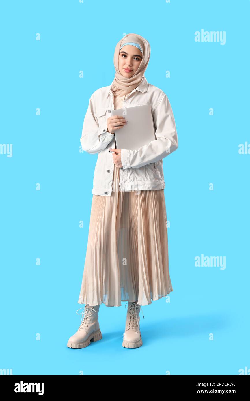 Arabian female programmer with laptop on blue background Stock Photo ...