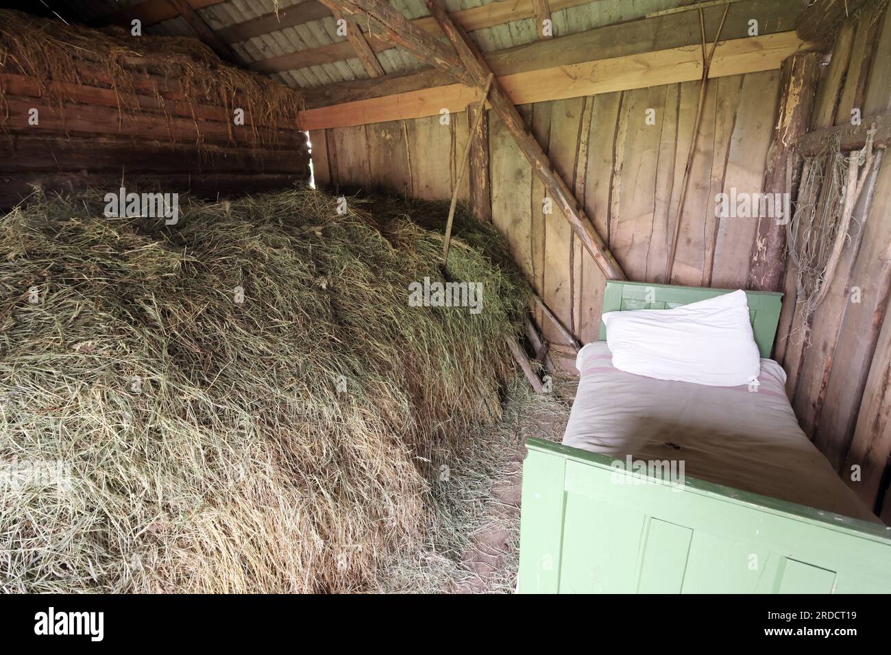 Hay in an old village barn. There is an old wooden bed Stock Photo - Alamy