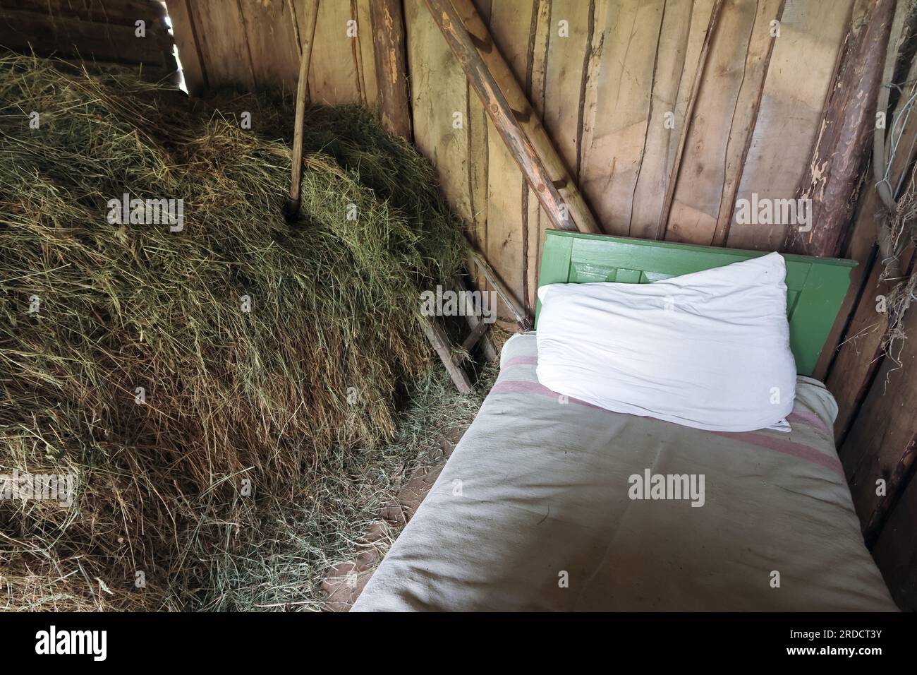 Hay in an old village barn. There is an old wooden bed Stock Photo - Alamy