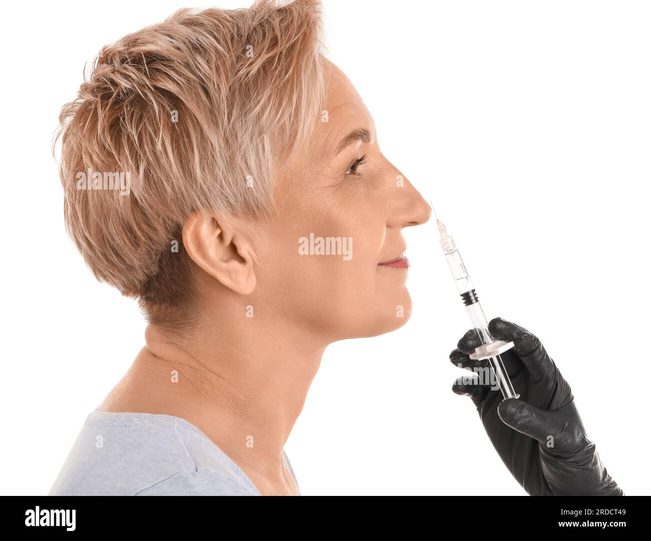 Mature woman receiving filler injection on white background, closeup ...