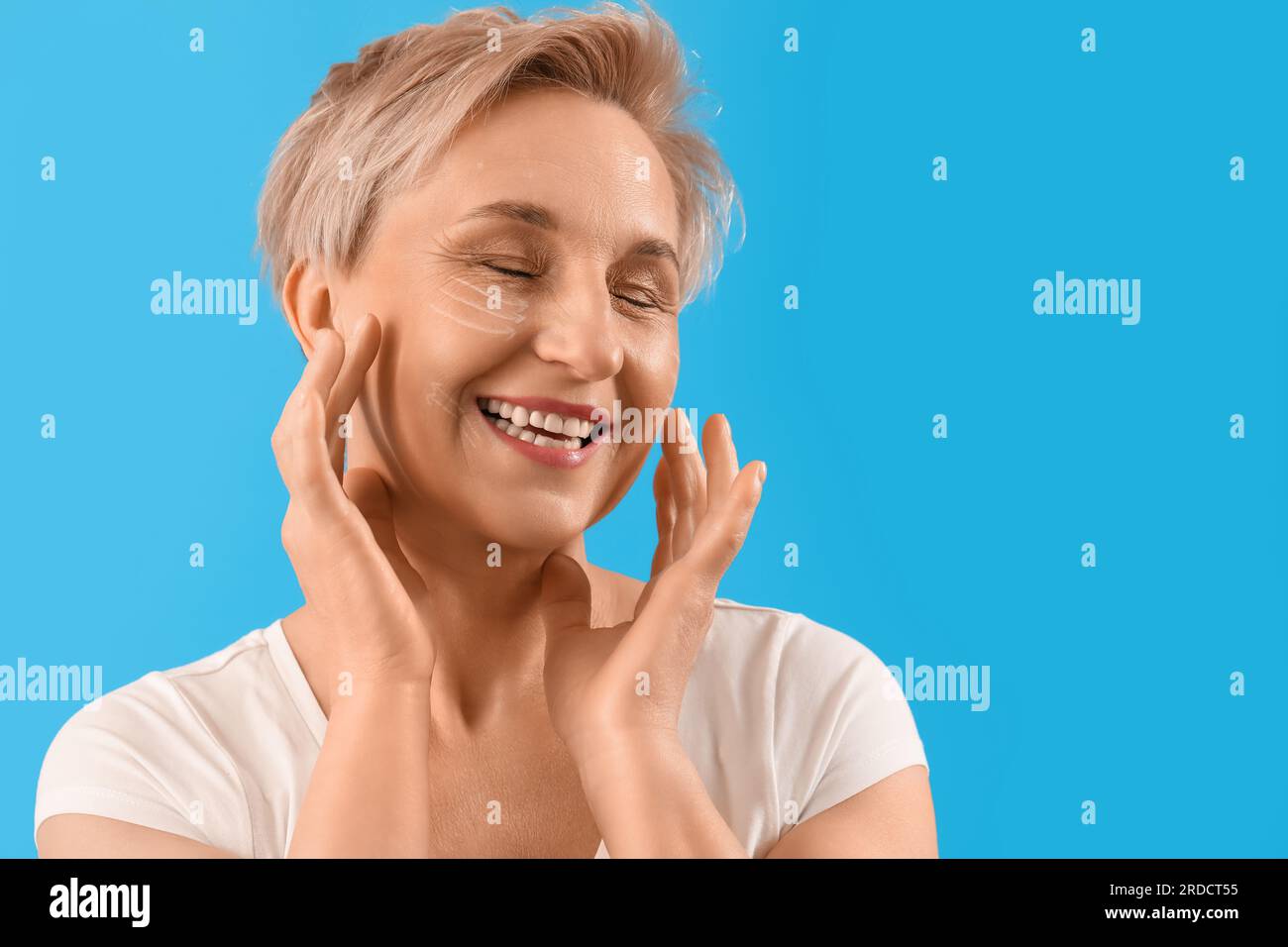 Mature woman with marked face for filler injection on blue background ...