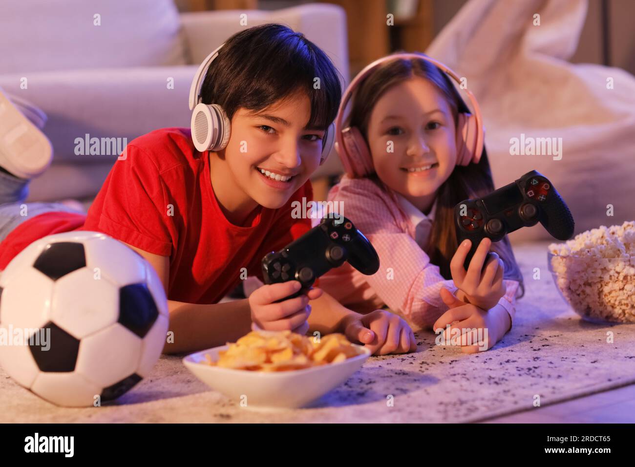 Little children playing video game at home in evening Stock Photo - Alamy