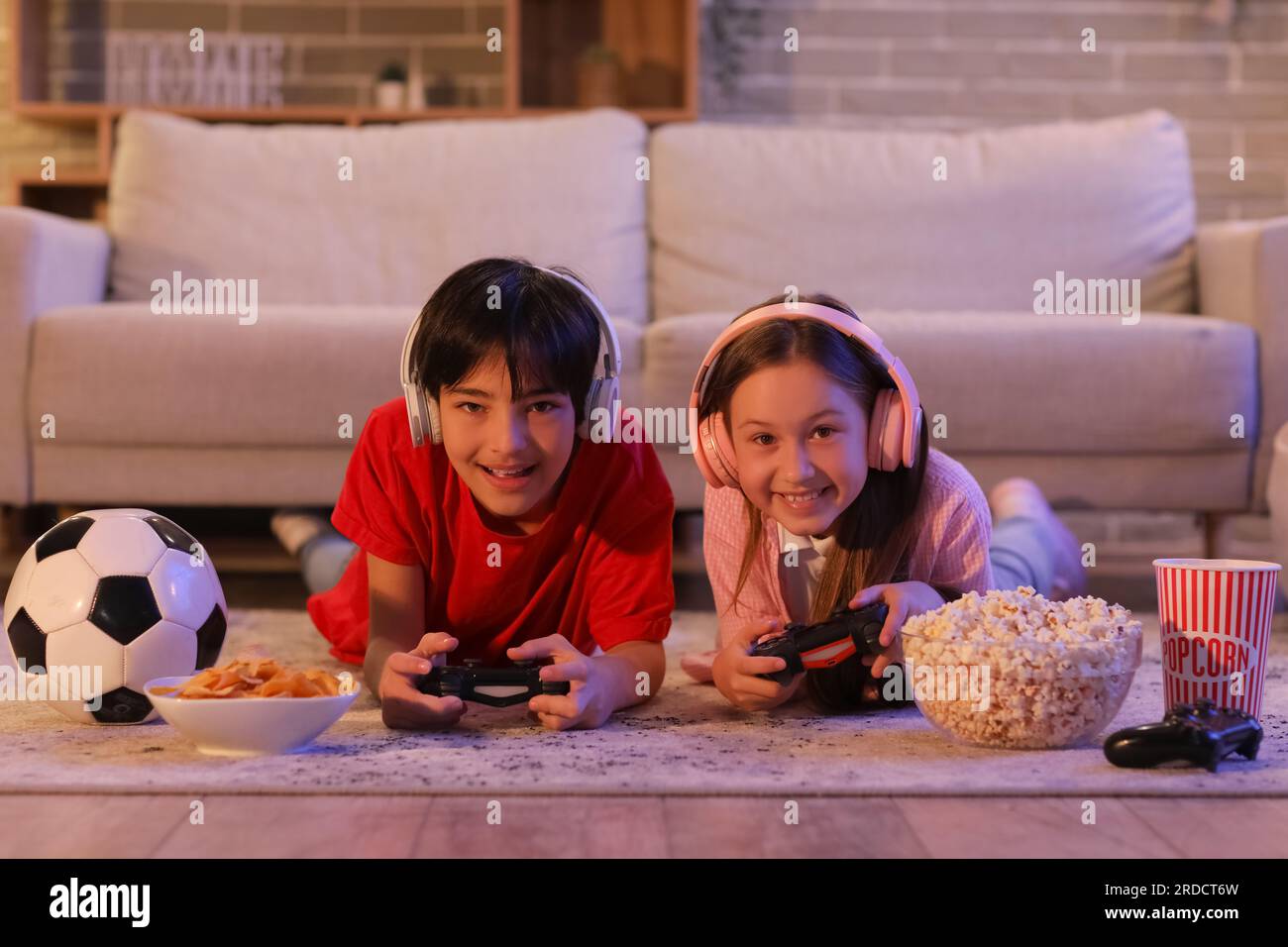 Little children playing video game at home in evening Stock Photo - Alamy