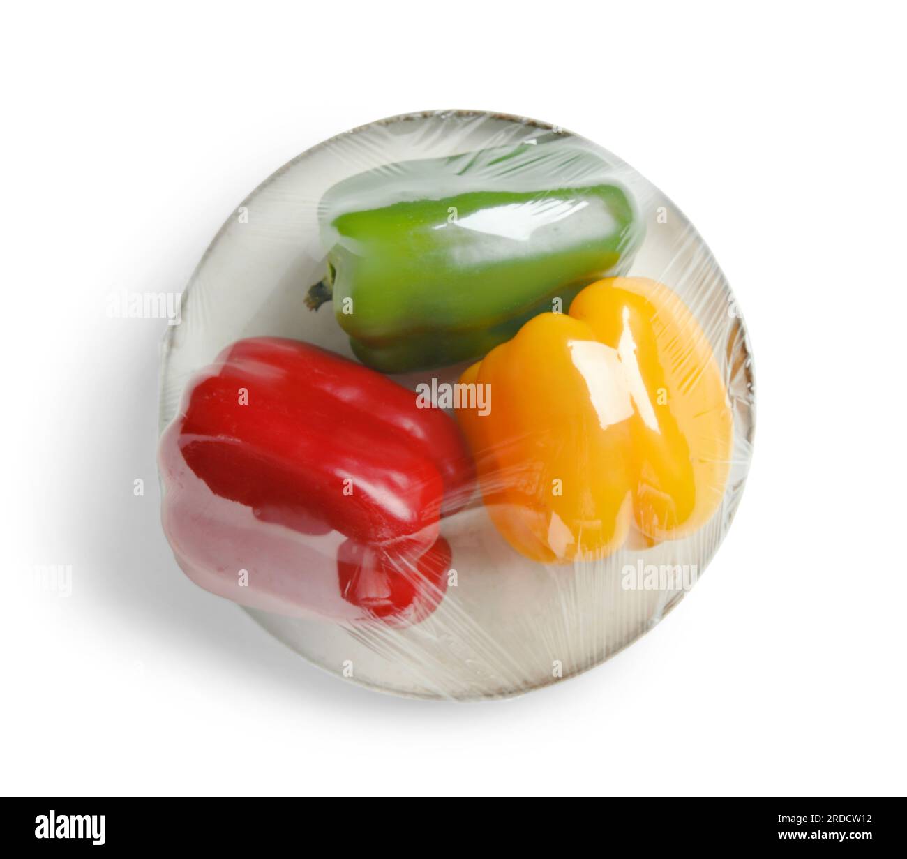 Plastic food wrap with sweet peppers on white background Stock Photo ...