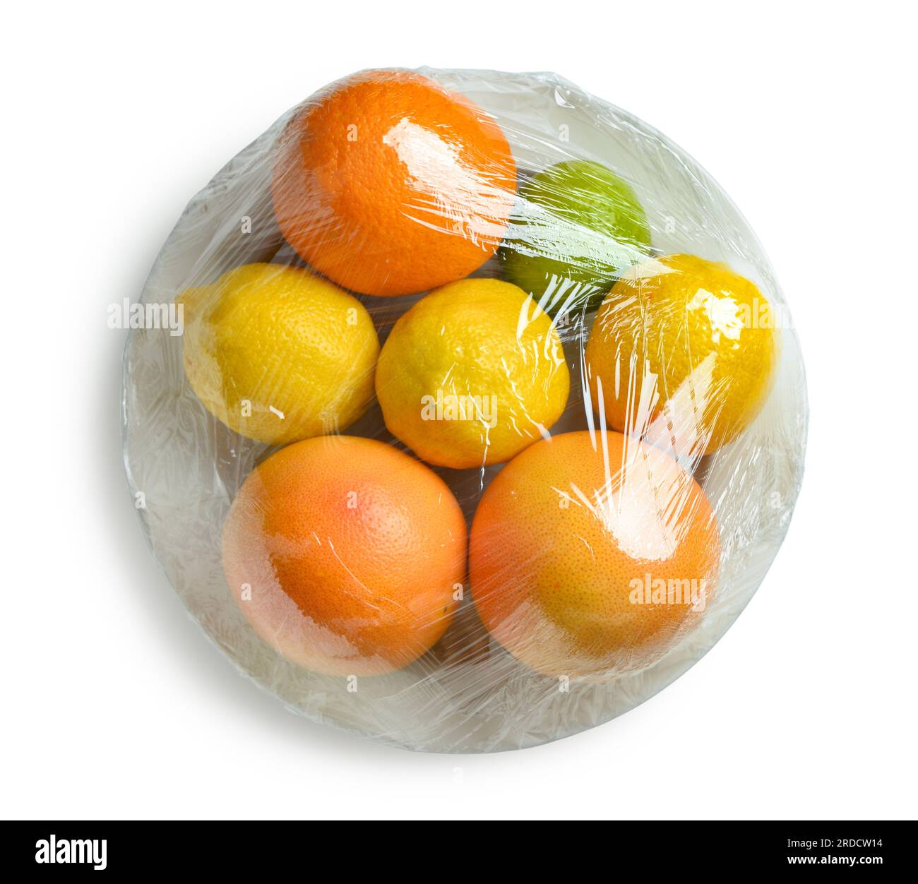 Plastic food wrap with different citrus fruits on white background ...