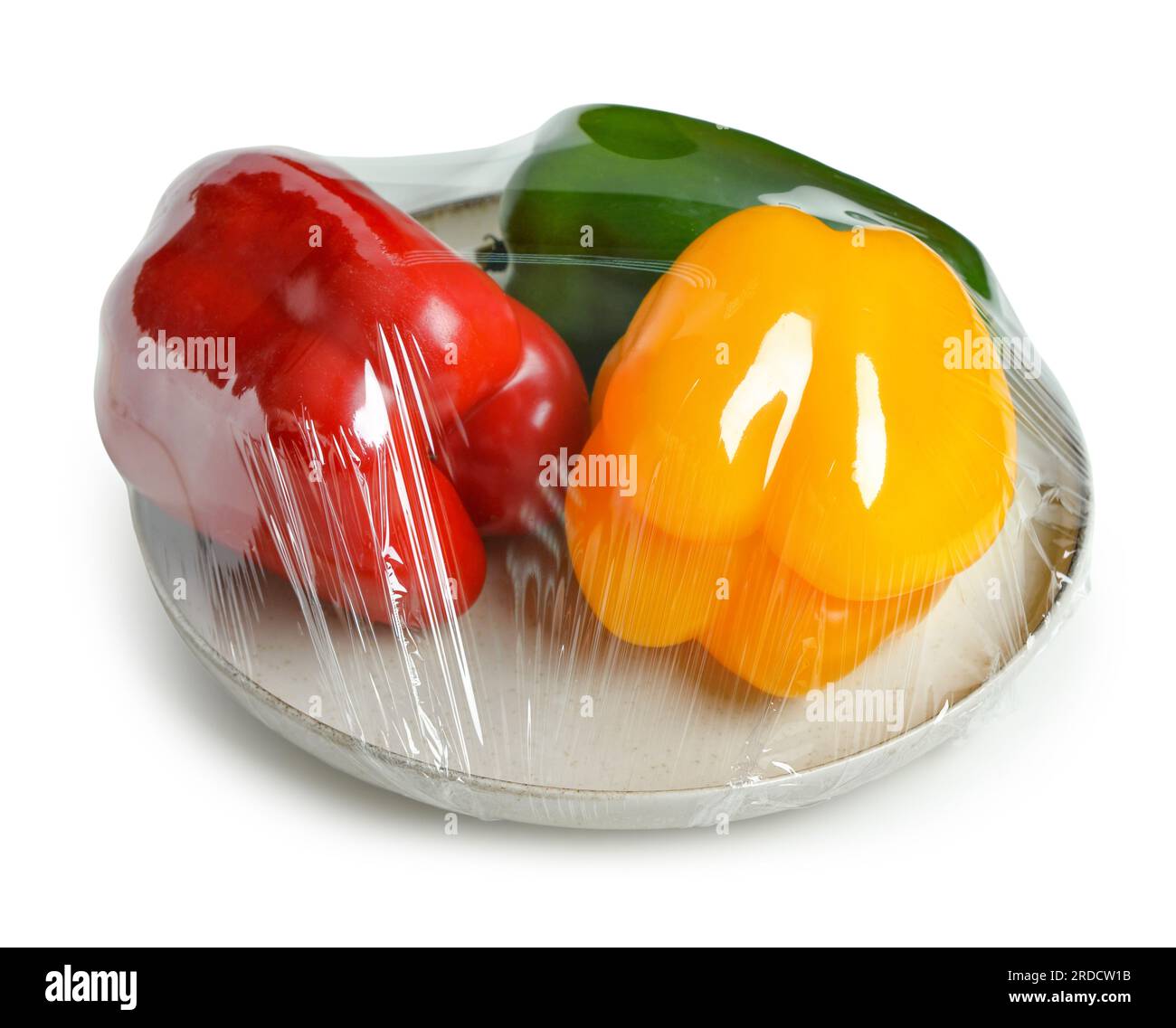 Plastic food wrap with sweet peppers on white background Stock Photo ...