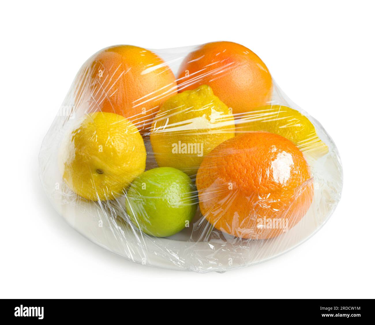 Plastic food wrap with different citrus fruits on white background ...