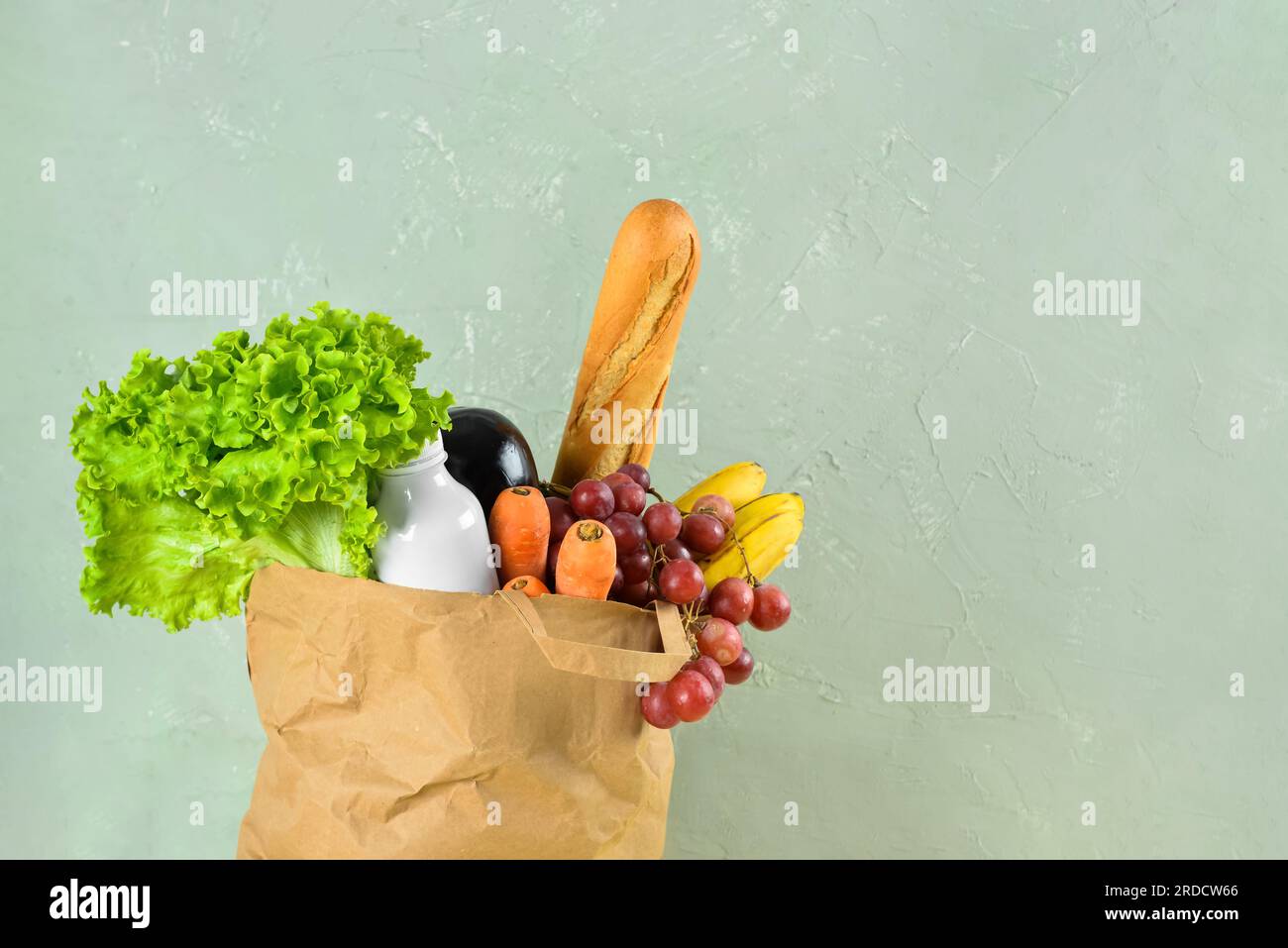 Paper bag full of fresh food on color background. Food delivery concept ...