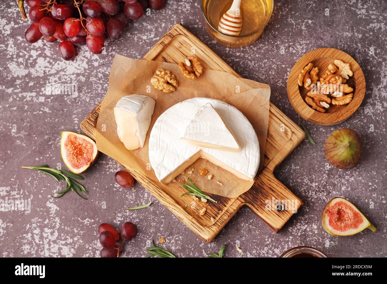 Wooden board with tasty Camembert cheese on grey background Stock Photo ...
