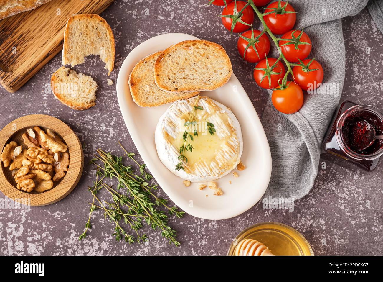 Plate of tasty baked Camembert cheese on grey background Stock Photo ...