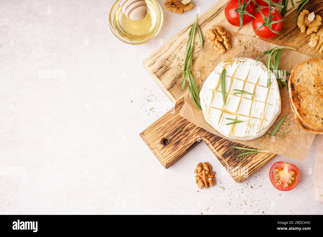 Wooden board with tasty baked Camembert cheese on light background ...