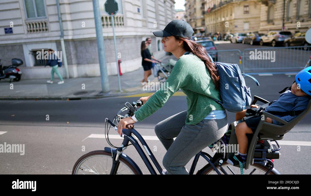 Cyclist mother riding bike with child Stock Photo - Alamy