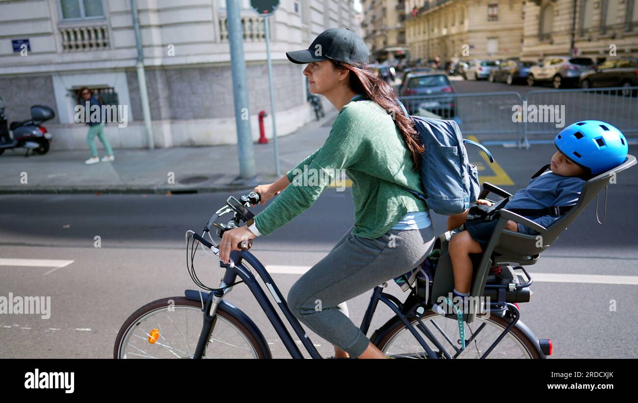 Cyclist mother riding bike with child Stock Photo - Alamy