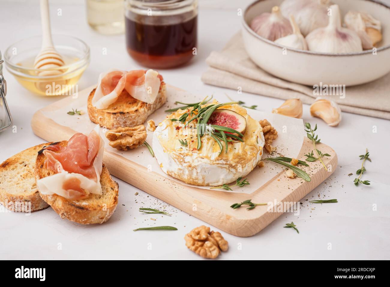 Wooden board with tasty baked Camembert cheese on grey background Stock ...