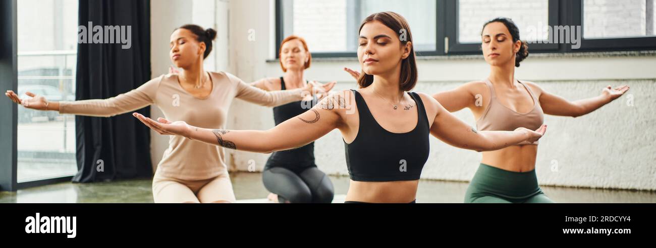 diverse multicultural female friends in sportswear practicing yoga and ...