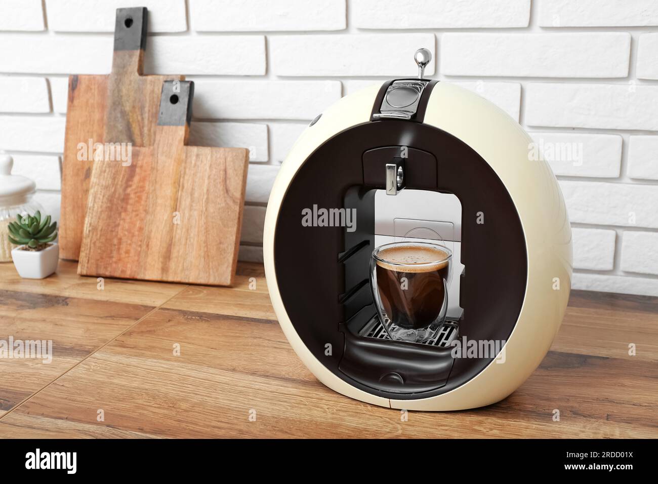 Modern coffee machine with glass of hot espresso on table in kitchen ...